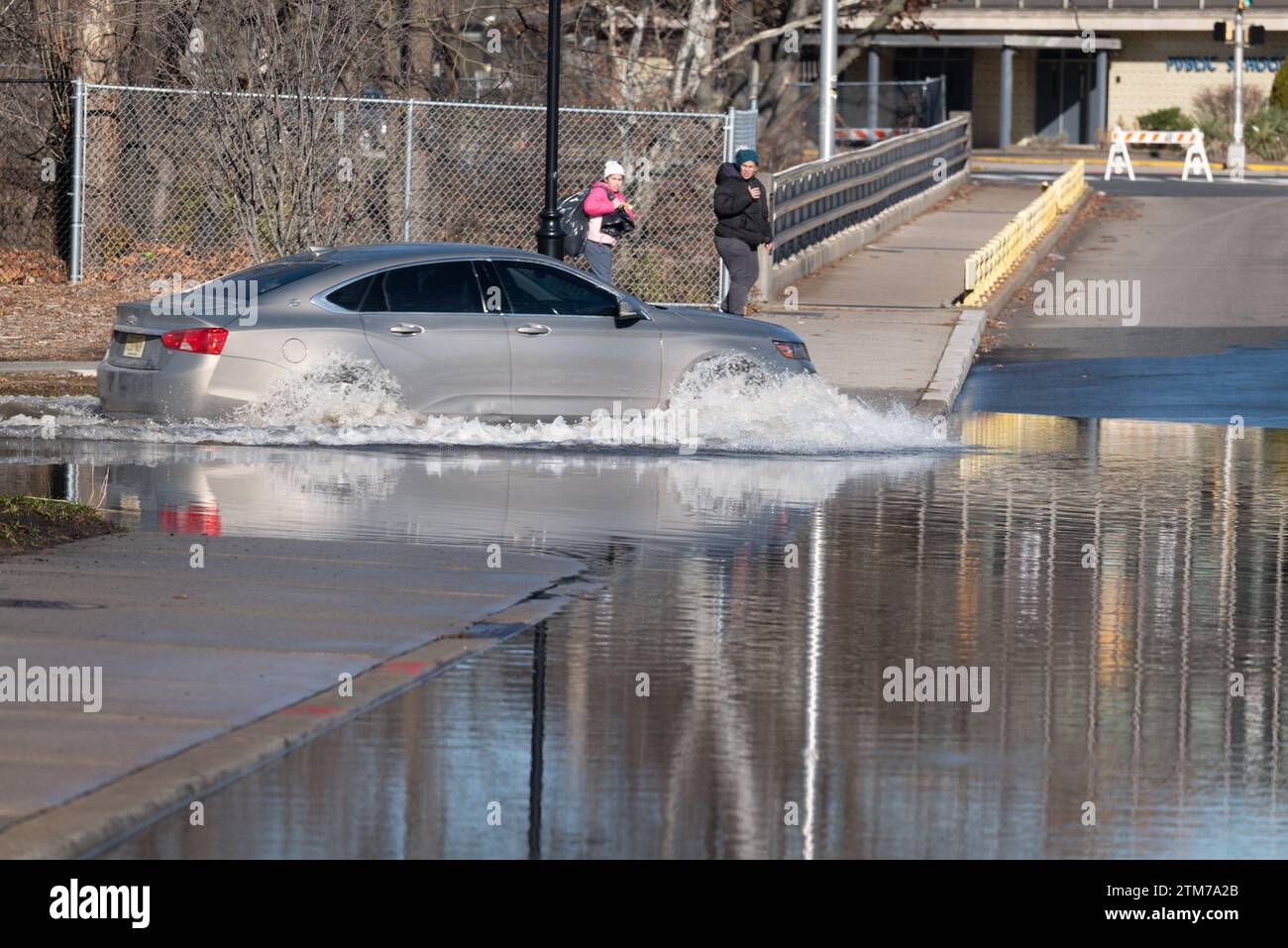 Paterson, New Jersey, USA. 20th Dec, 2023. Onlookers watch a car drive ...
