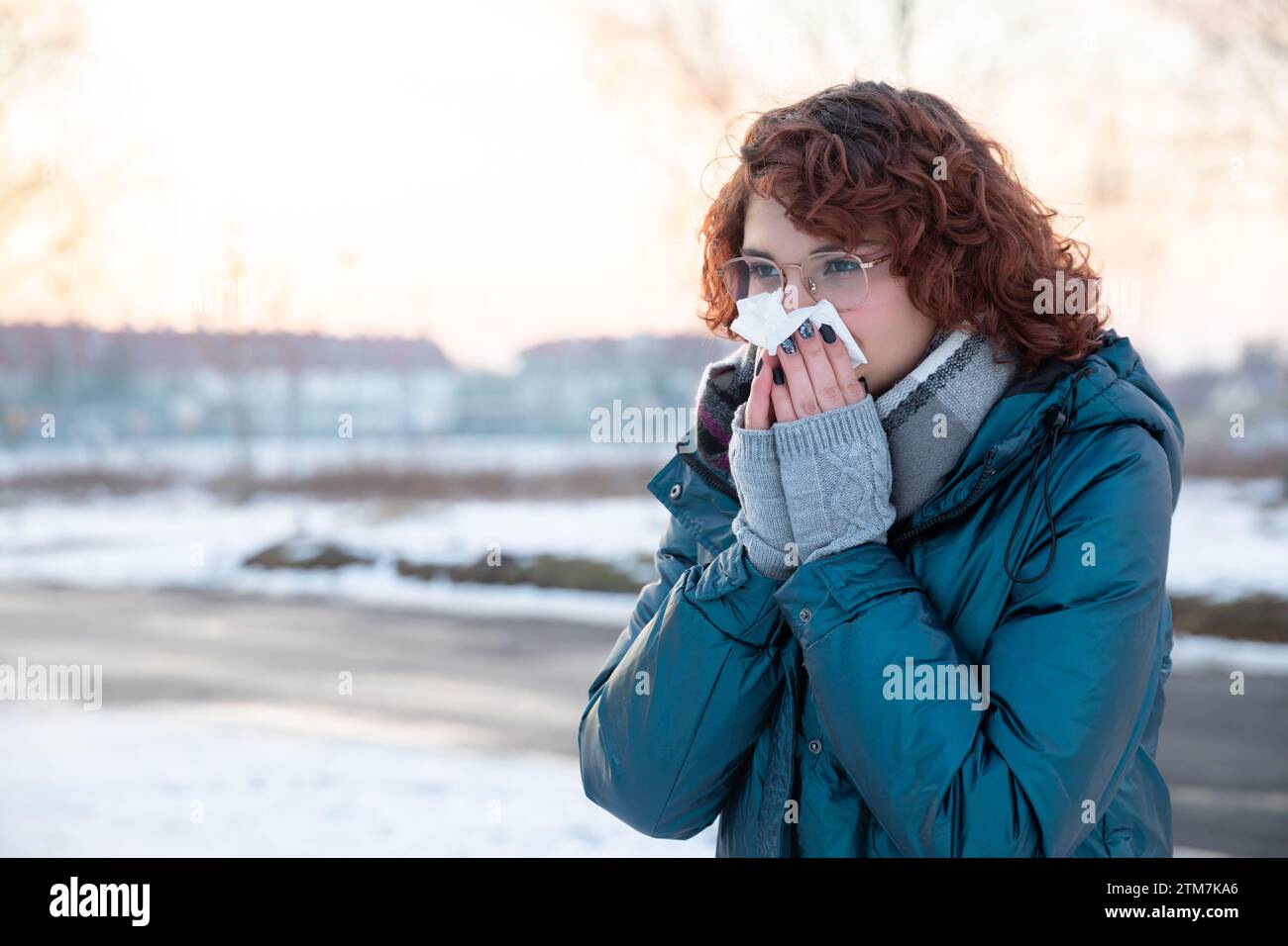 A frozen girl with glasses wipes her nose in a tissue Stock Photo - Alamy