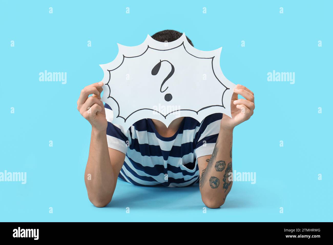 Young man holding paper with question mark on blue background Stock ...