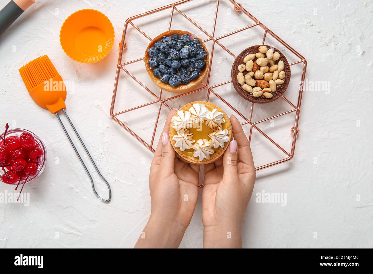 Female confectioner with tasty cakes on white background Stock Photo ...