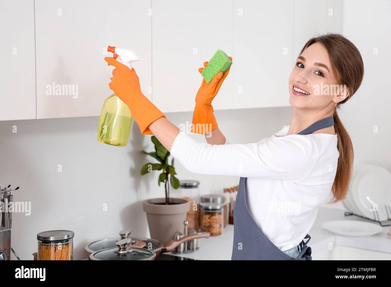 Female janitor with detergent and cleaning sponge in kitchen Stock ...
