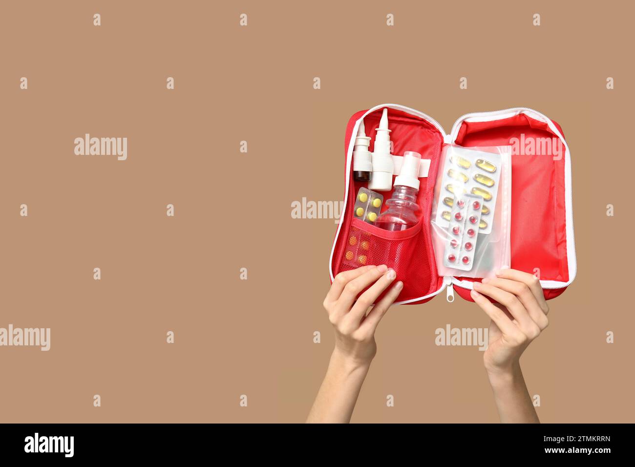 Female hands holding first aid kit with pills and medicine bottles on ...