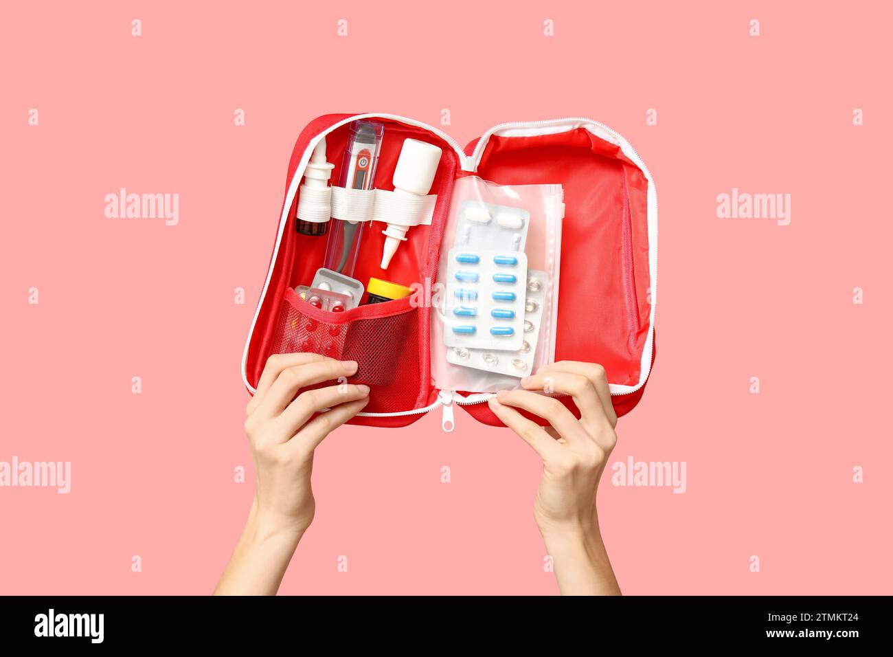 Female hands holding first aid kit with pills and medicine bottles on ...