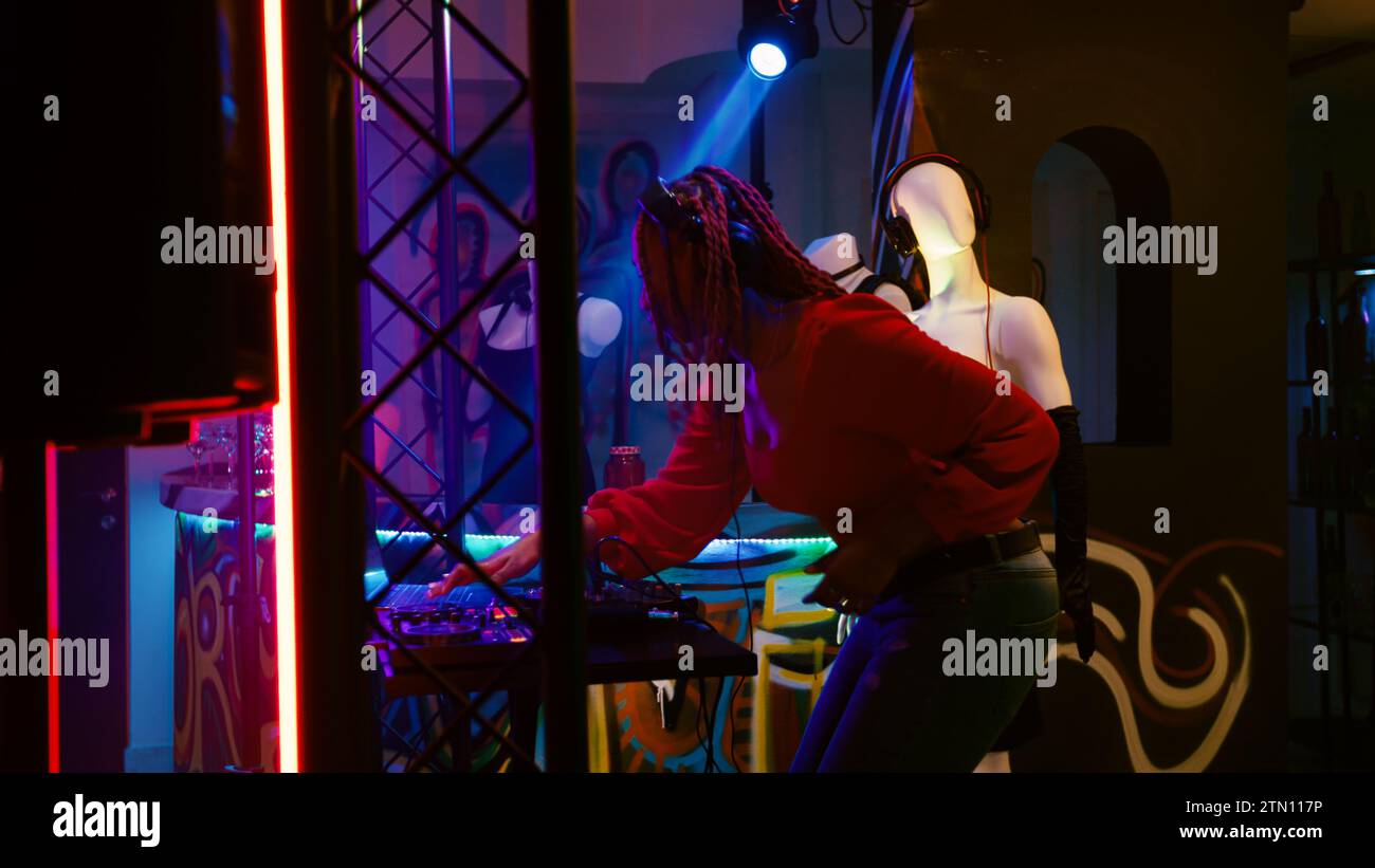 Woman DJ putting funky music on stage, using audio mixing station at ...