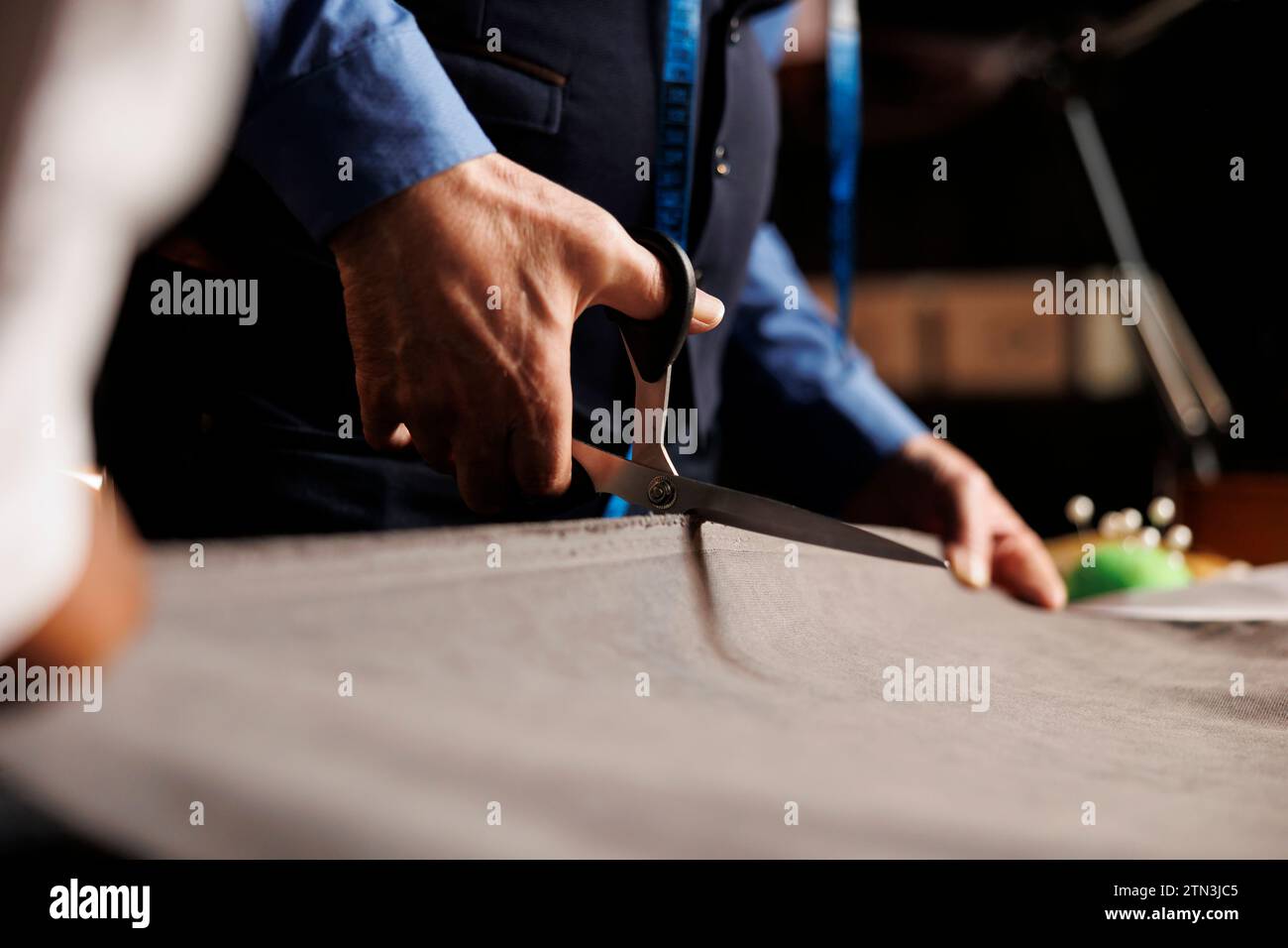 Fashion industry specialists manufacturing suit in atelier workspace ...
