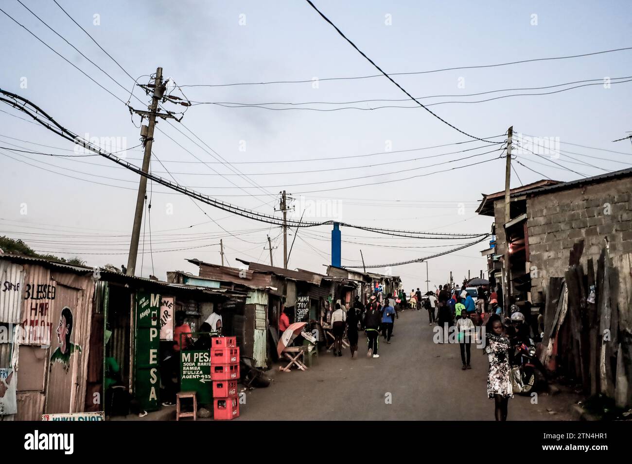 Pedestrians walk past the busy streets in Kibera Slum, Nairobi. A view ...