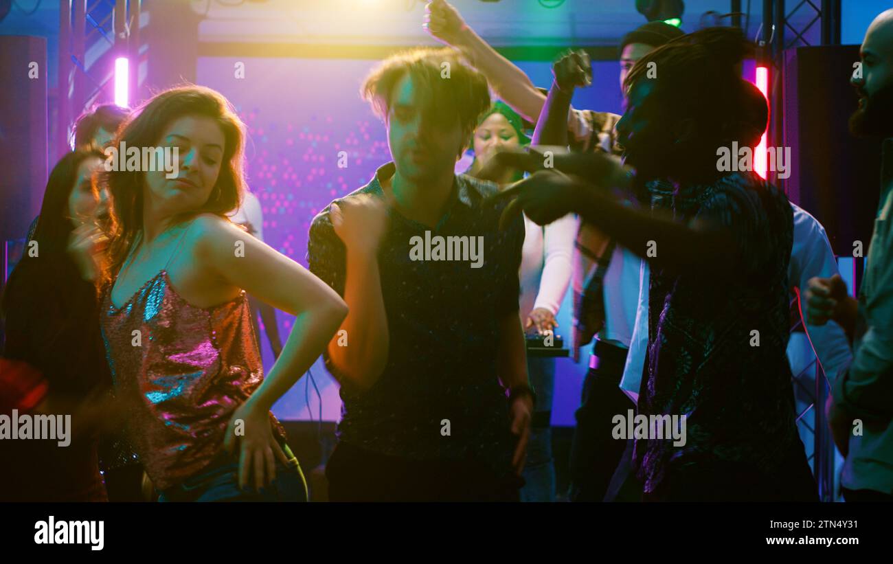 Diverse friends jumping at dance party, having fun with spotlights and ...