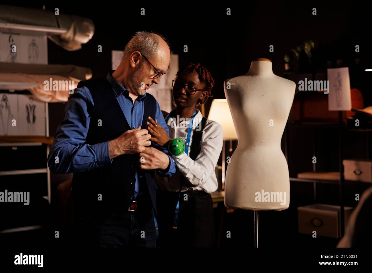 Senior businessman trying on bespoke stylish suit vest before important ...