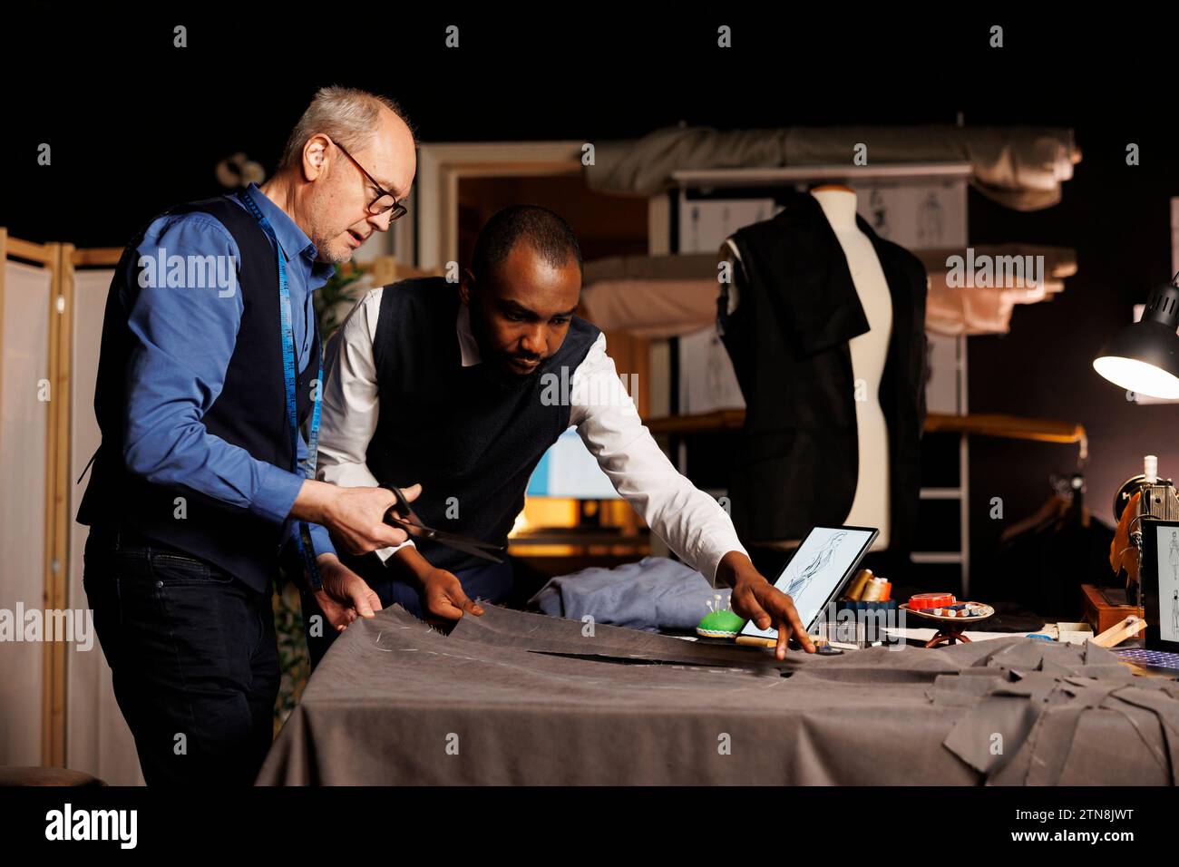 Skilled dressmakers preparing textile material for handmade stylish ...