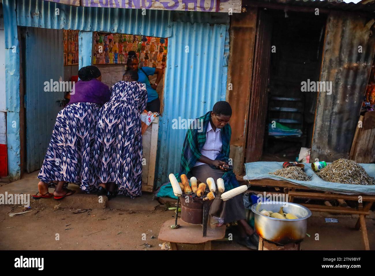 A hawker sells foodstuff by the busy streets in Kibera Slum, Nairobi. A ...