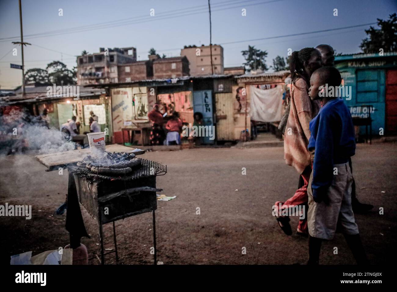 Residents walk past the busy business streets in Kibera Slum, Nairobi ...