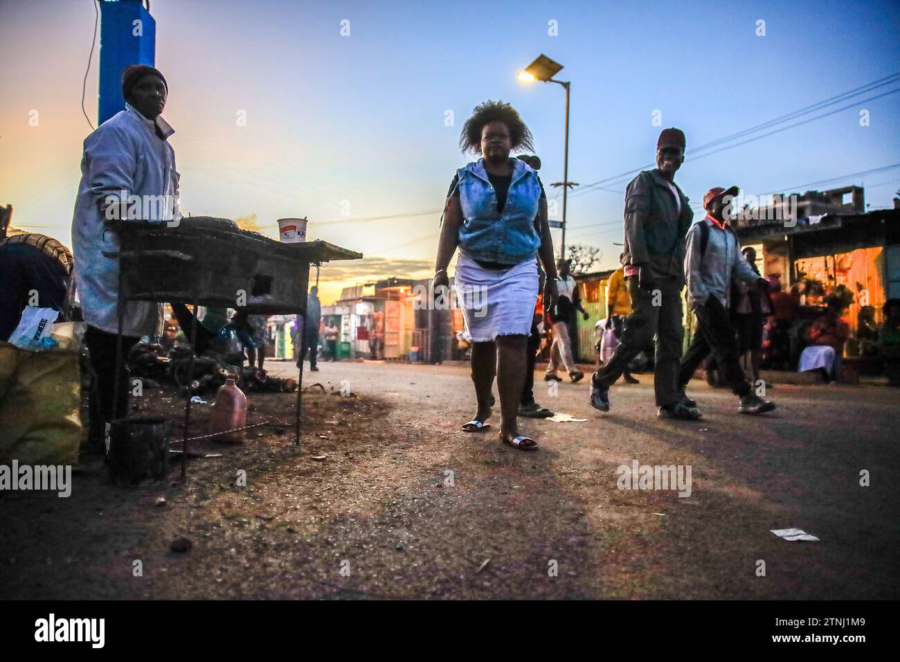 Residents walk past the busy business streets in Kibera Slum, Nairobi ...