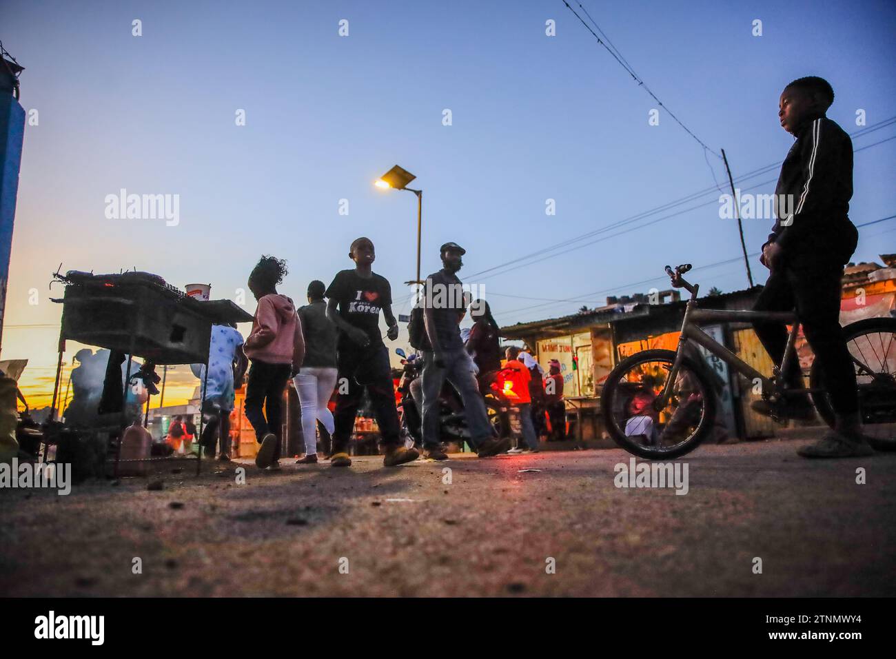 Residents walk past the busy business streets in Kibera Slum, Nairobi ...