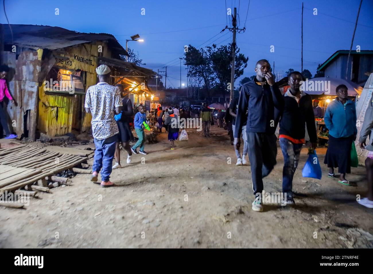 Residents walk past the busy business streets in Kibera Slum, Nairobi ...