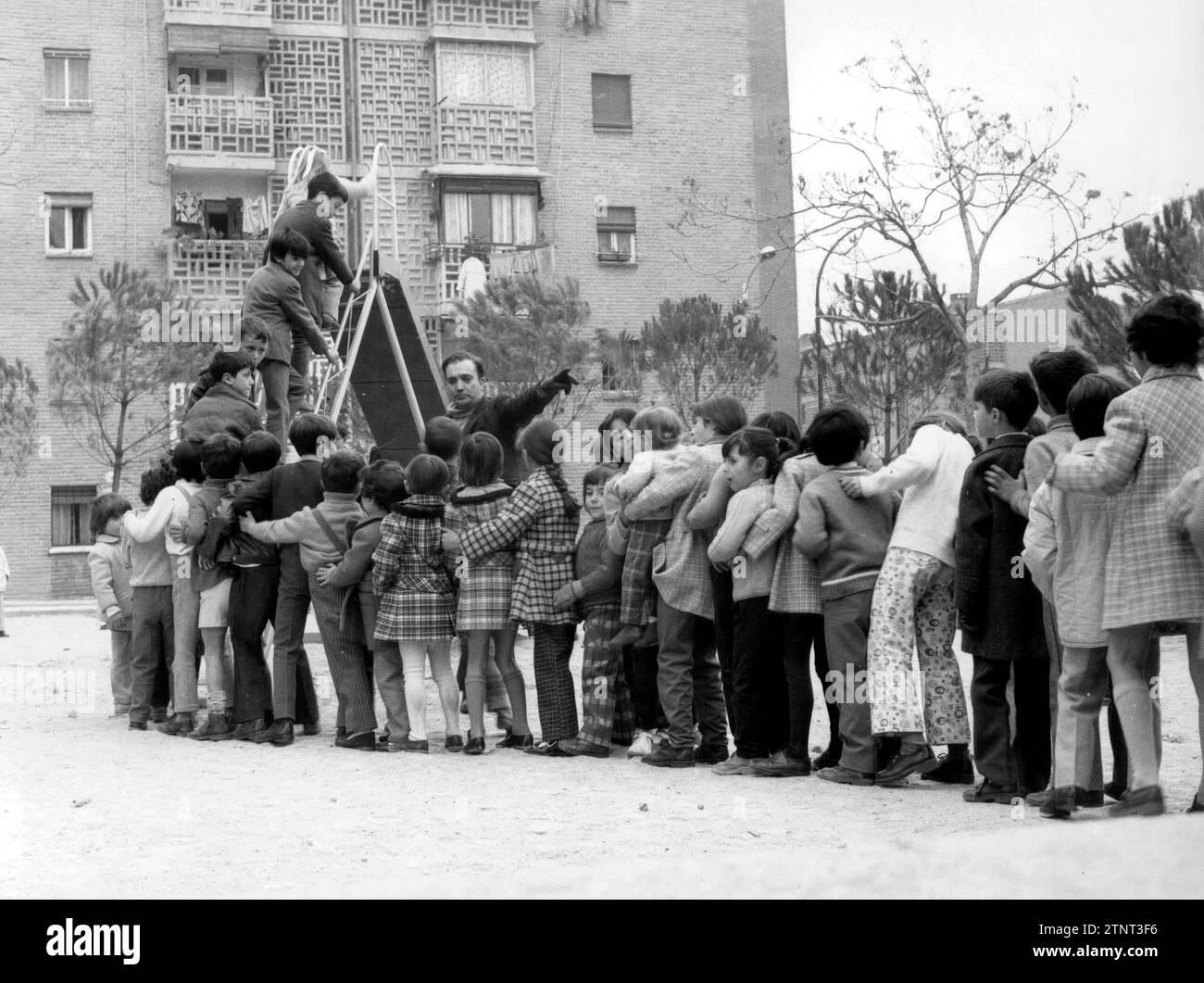 Madrid, December 1971. Some children queue to use a slide in a park ...