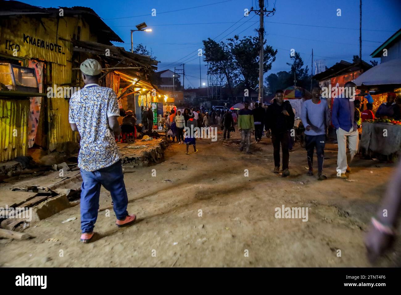 Residents walk past the busy business streets in Kibera Slum, Nairobi ...