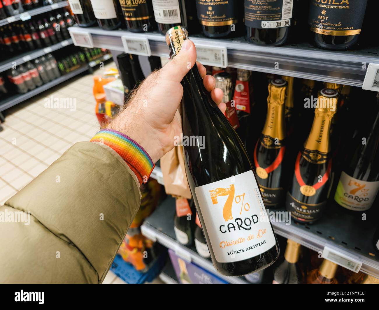 Paris, France - Nov 10, 2023: A male hand carefully chooses a bottle of ...