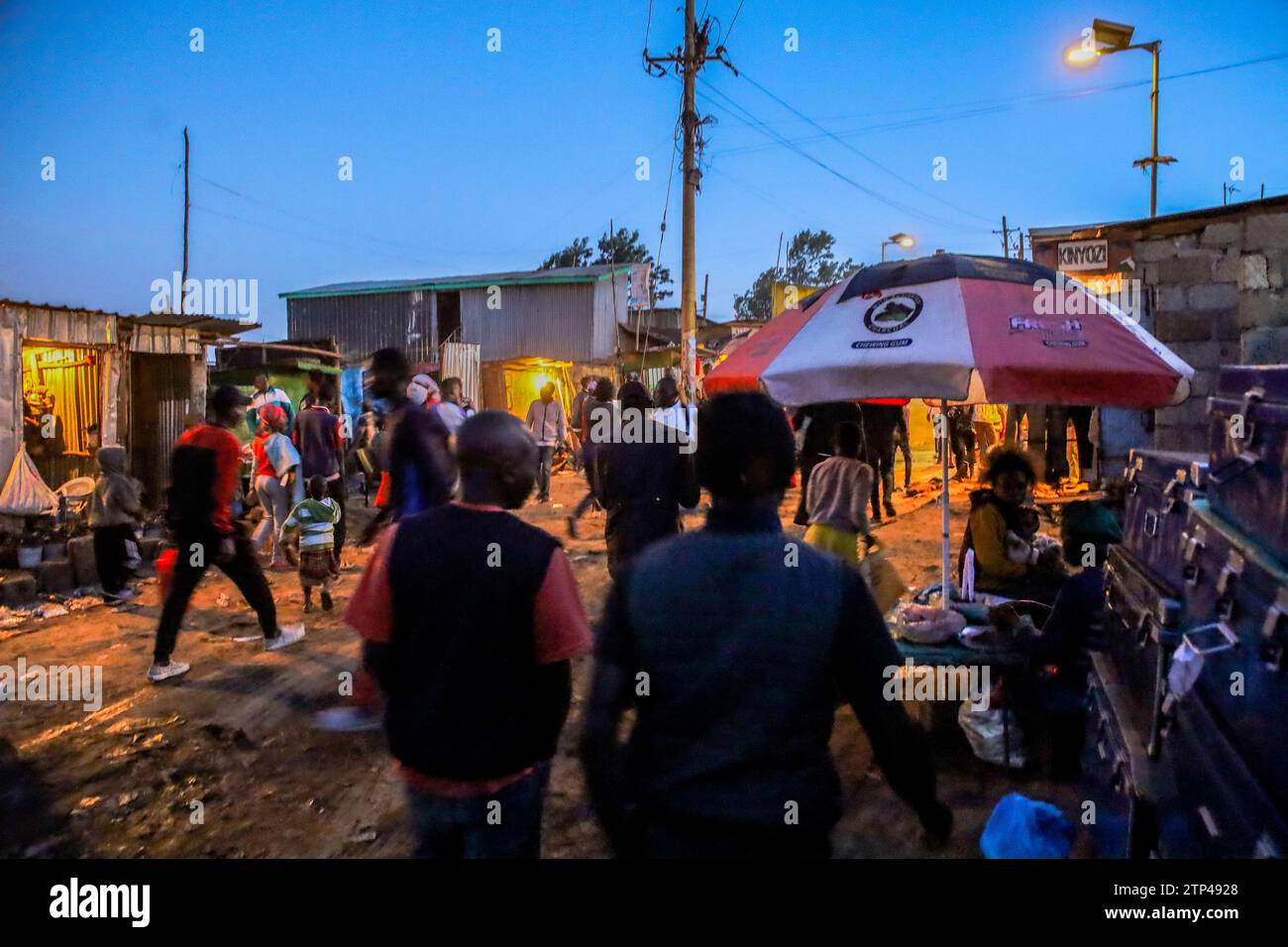 Residents walk past the busy business streets in Kibera Slum, Nairobi ...