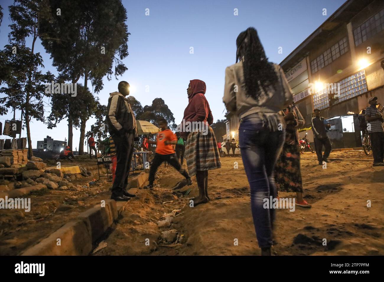 Residents walk past the busy business streets in Kibera Slum, Nairobi ...