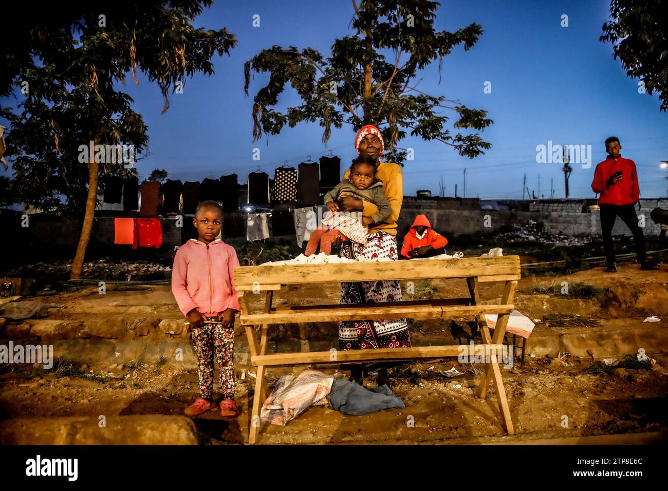 A hawker postures with her grandchildren in kibera Slum, Nairobi. A ...