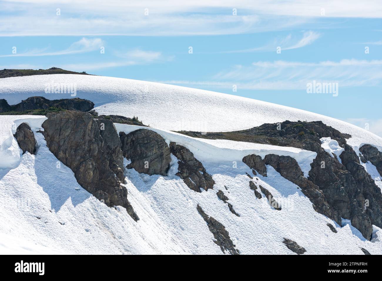 Contrast of snow and stone shapes the ridge against a clear sky Stock ...