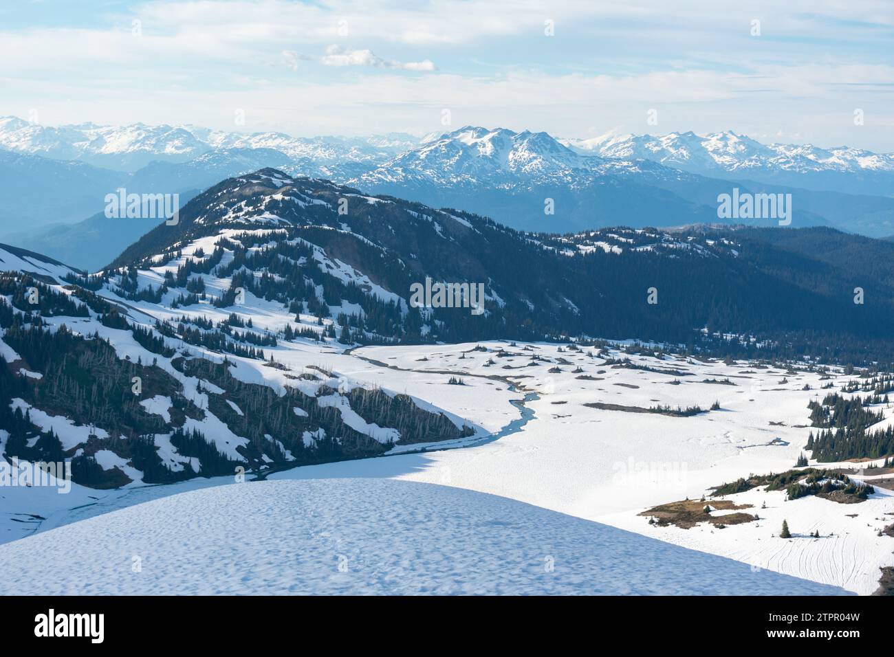 Serene British Columbia mountainscape with snow patches and distant ...