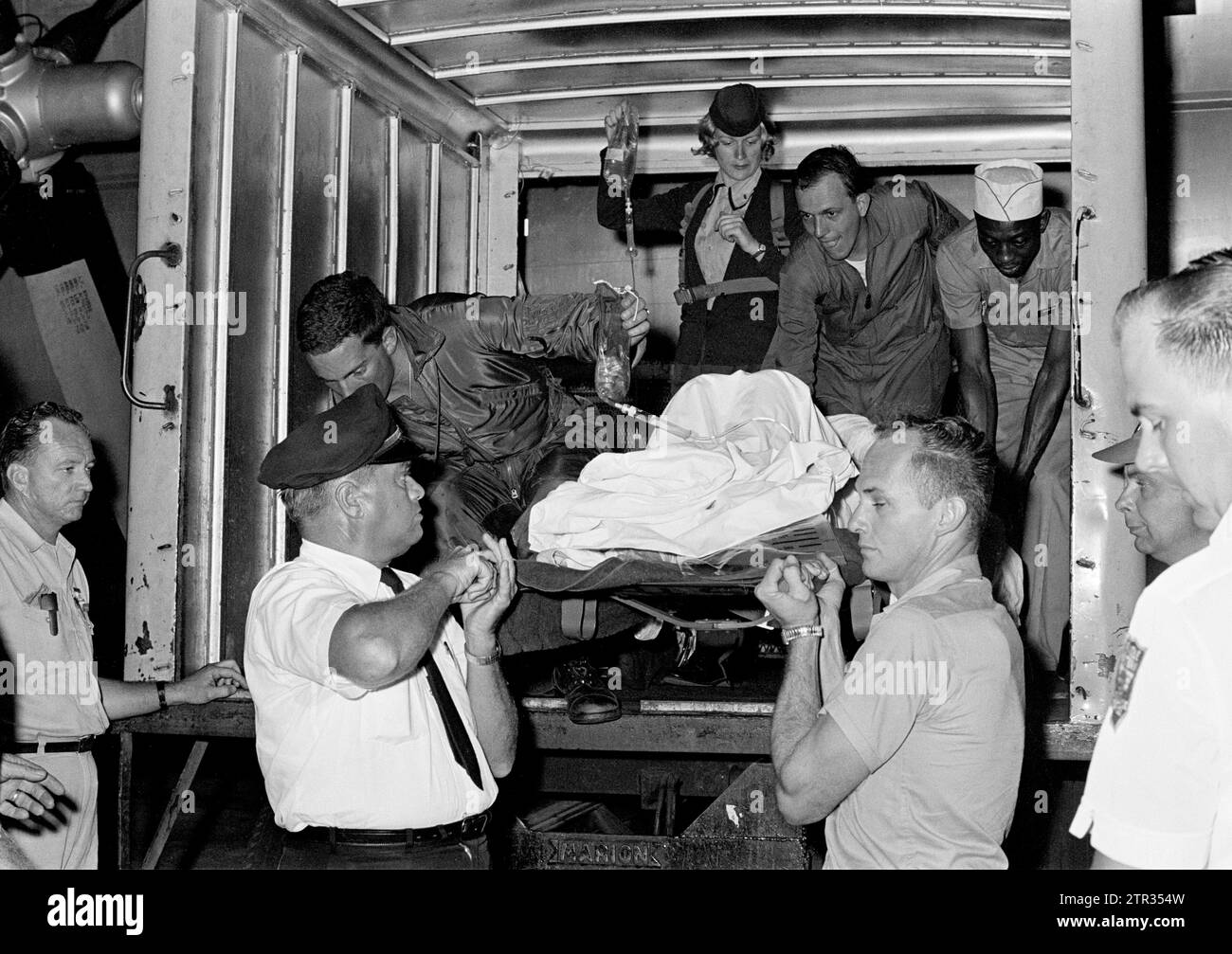 Nurse and airman hold plasma bottles as a badly burned survivor of the ...