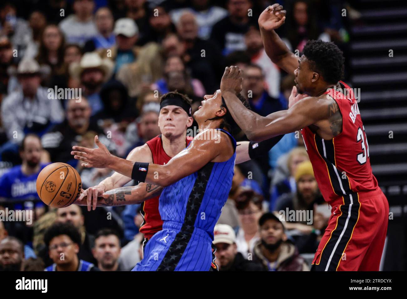 Orlando Magic forward Paolo Banchero, middle, is defended by Miami Heat ...