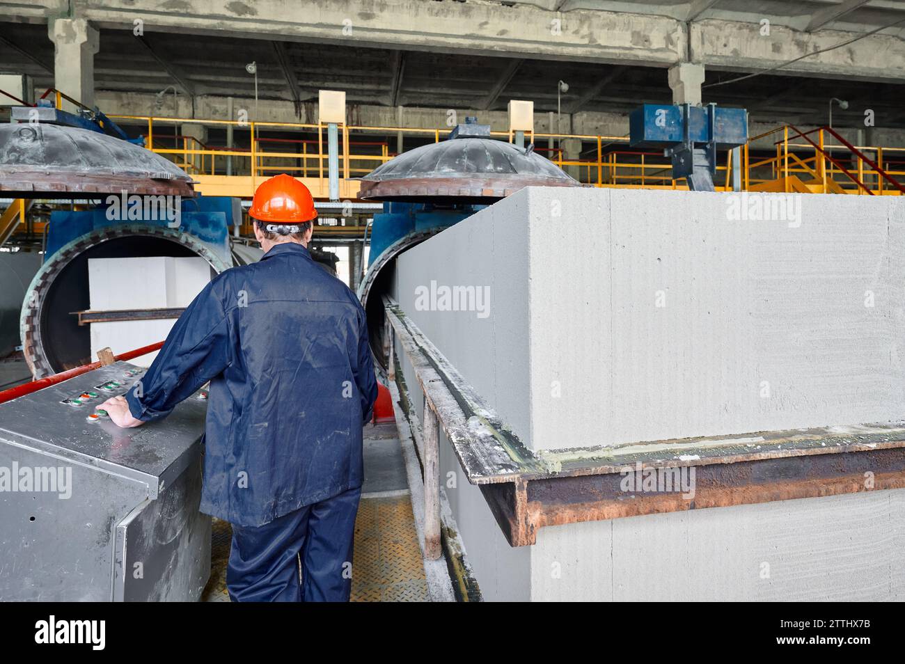 Worker in helmet loads raw blocks into open autoclaves Stock Photo - Alamy