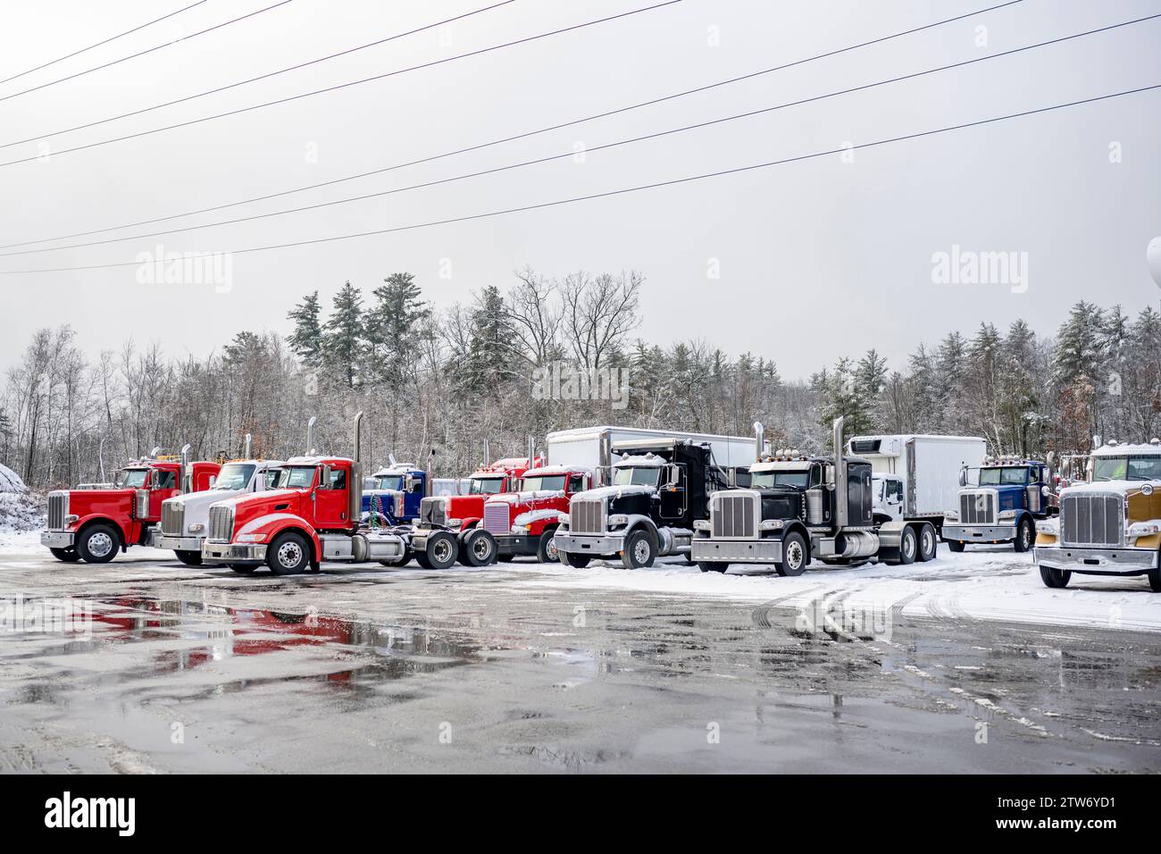 Big rig semi trucks with semi trailers standing in row on the industry ...