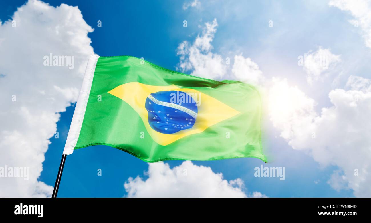 Brazilian flag waving against blue sky background Stock Photo - Alamy
