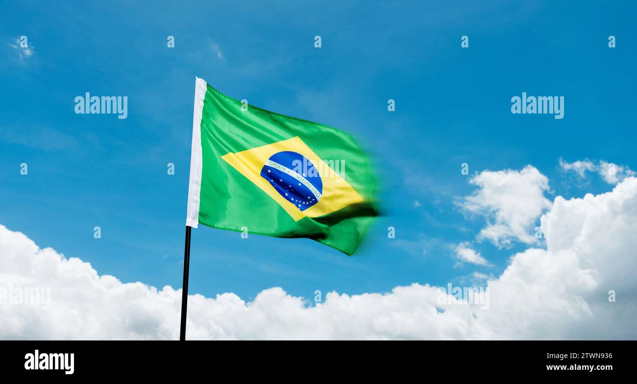 Brazilian flag waving against blue sky background Stock Photo - Alamy
