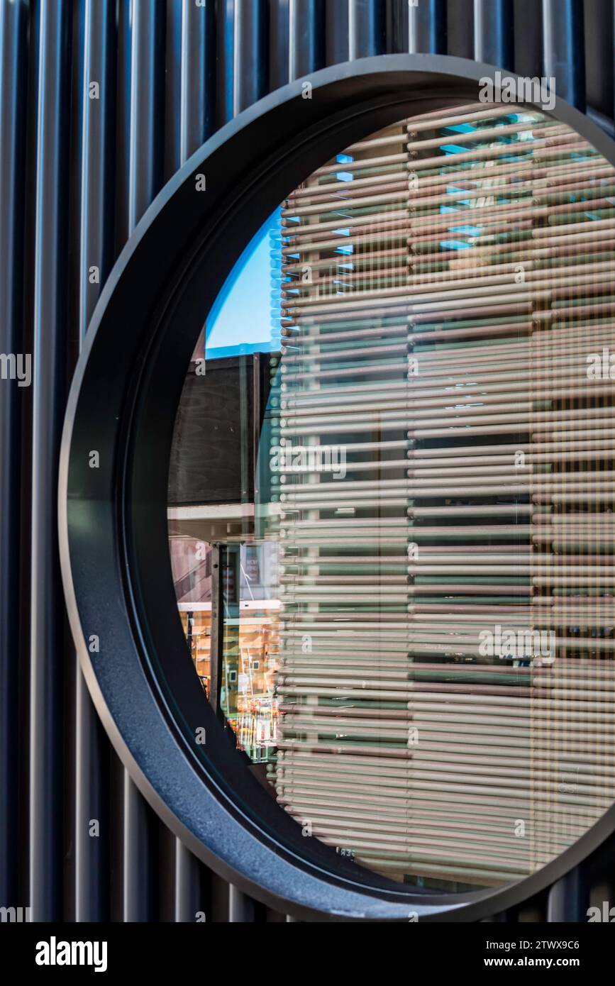 Reflections in a circular window embedded in a vertically lined steel ...