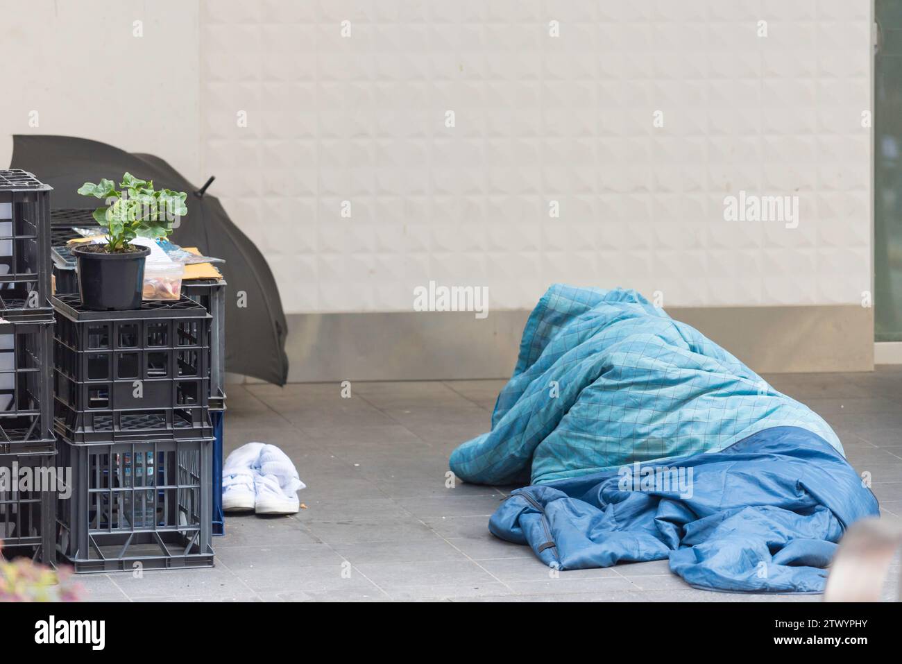 A homeless person with just a few personal belongings, sleeping on the ...