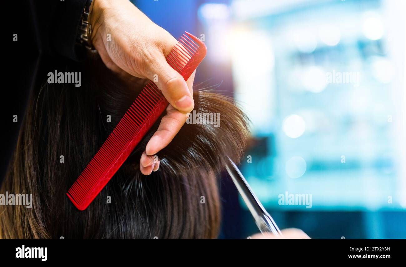 Hairdresser cuts asian hair with scissors Stock Photo - Alamy