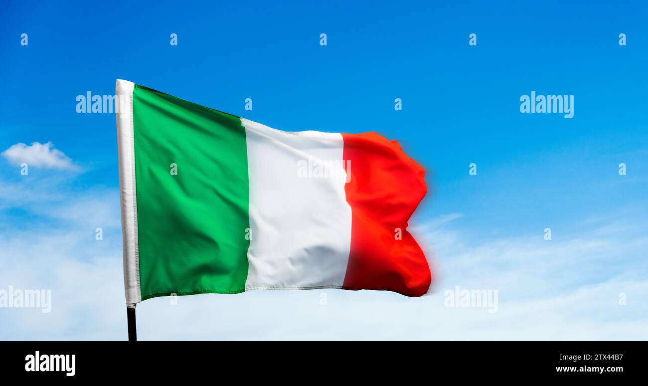 Italian flag waving on blue sky background Stock Photo - Alamy