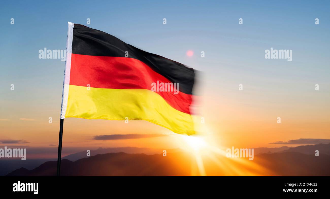 German flag waving against sunrise sky background Stock Photo - Alamy