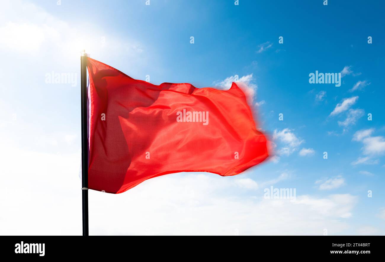 Red flag waving on blue sky Stock Photo - Alamy