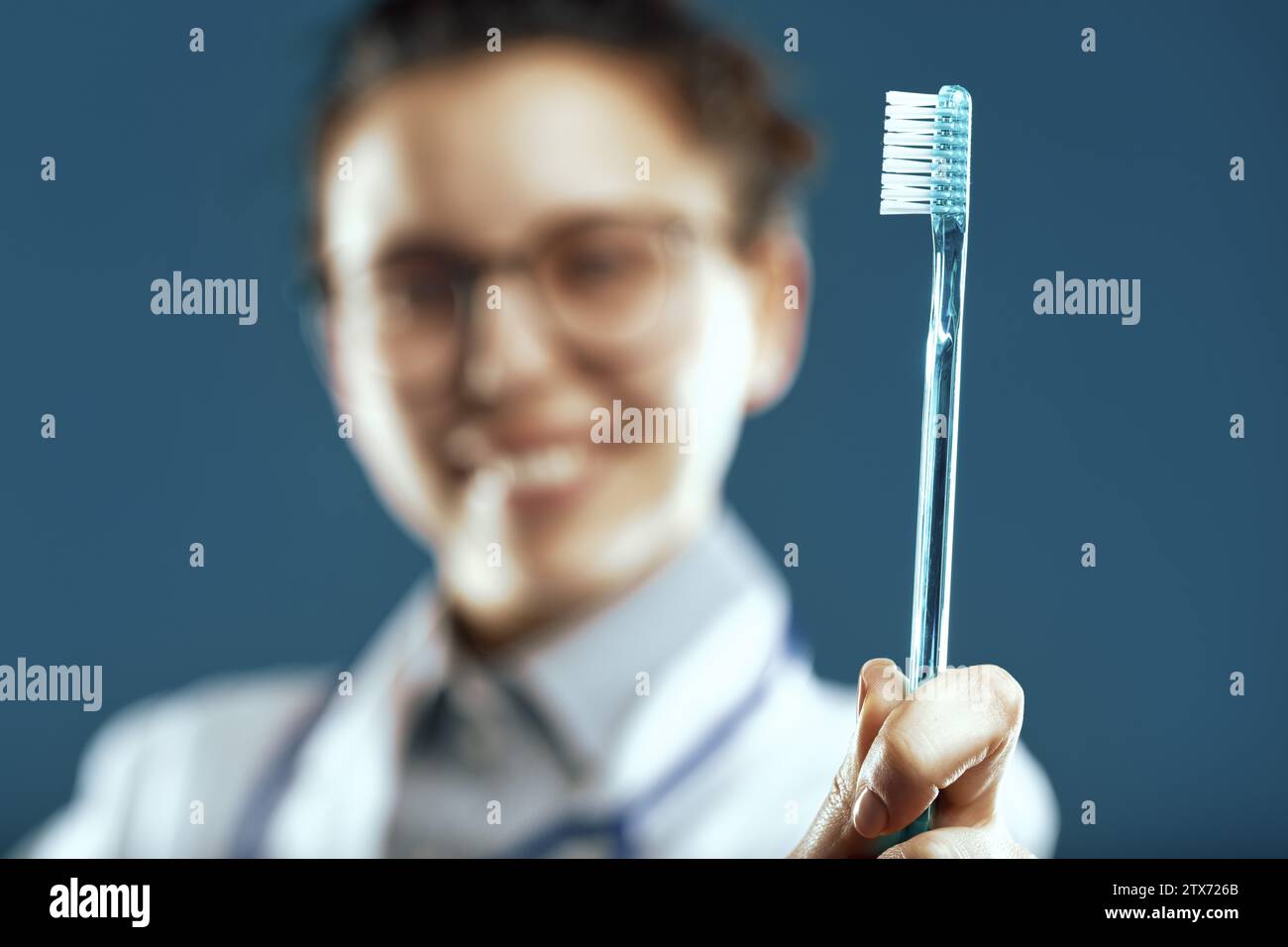 Dental professional presents a toothbrush, focus sharp on oral hygiene ...
