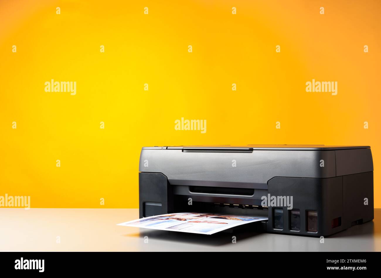 Printer on desk against yellow background studio shot Stock Photo - Alamy