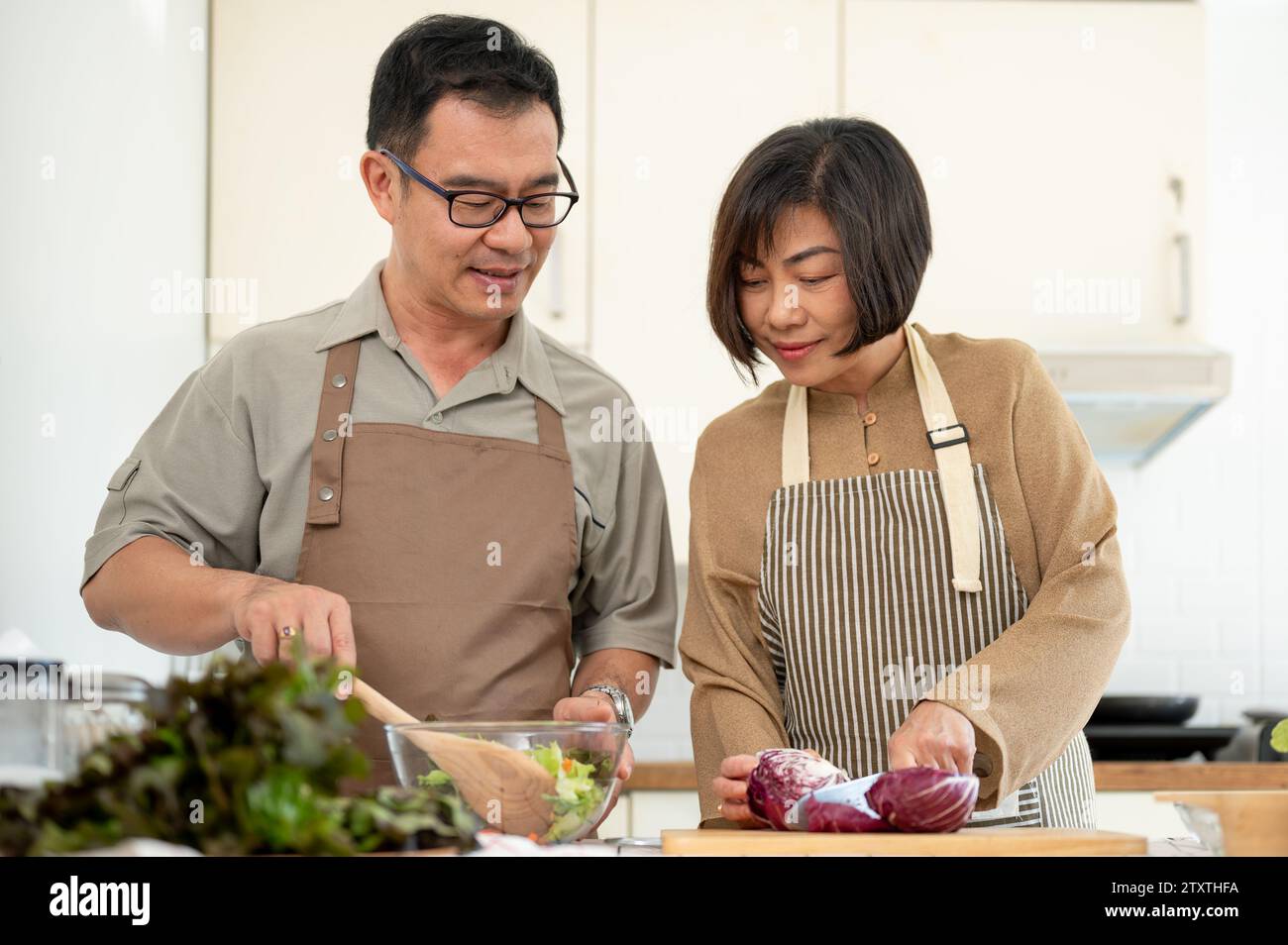 Lovely adult Asian husband and wife enjoy cooking, making a healthy ...