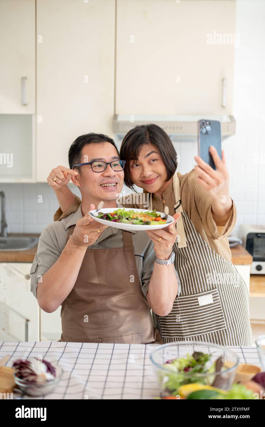 A lovely Asian couple taking pictures or selfies with their food in the ...