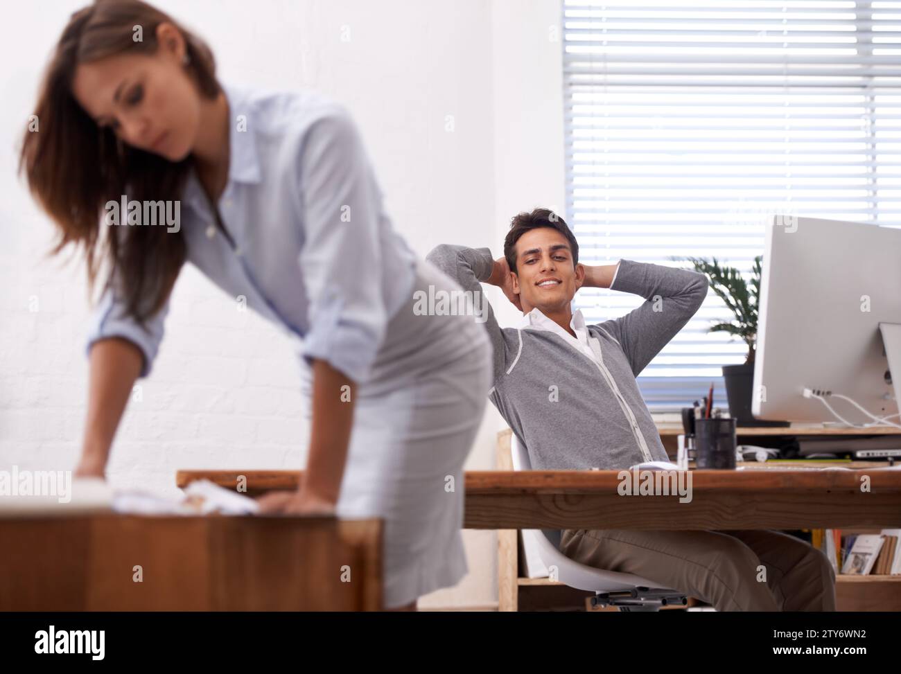 Man, relax and break on computer at the office looking at woman or ...