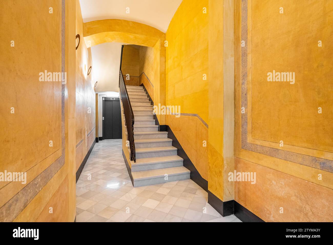 Stairs in yellow-walled hallway at entrance of building Stock Photo - Alamy
