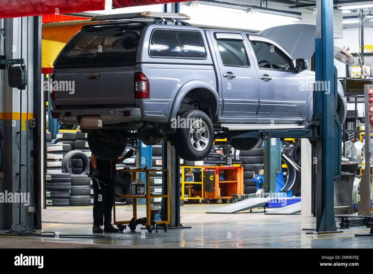 Pickup truck lifted into the air using a mechanical bridge jack in a ...