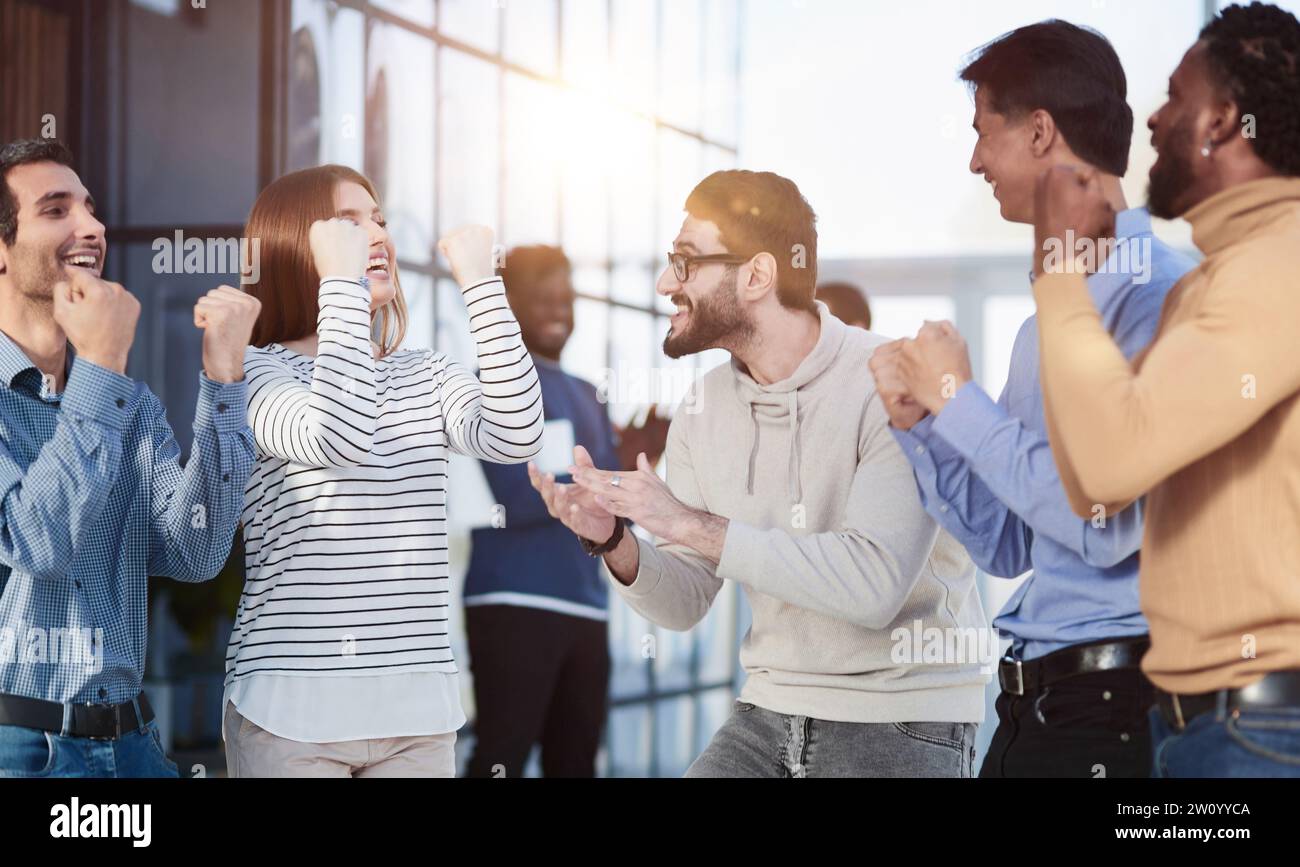 Business people celebrates and clench their fists in the air as a ...