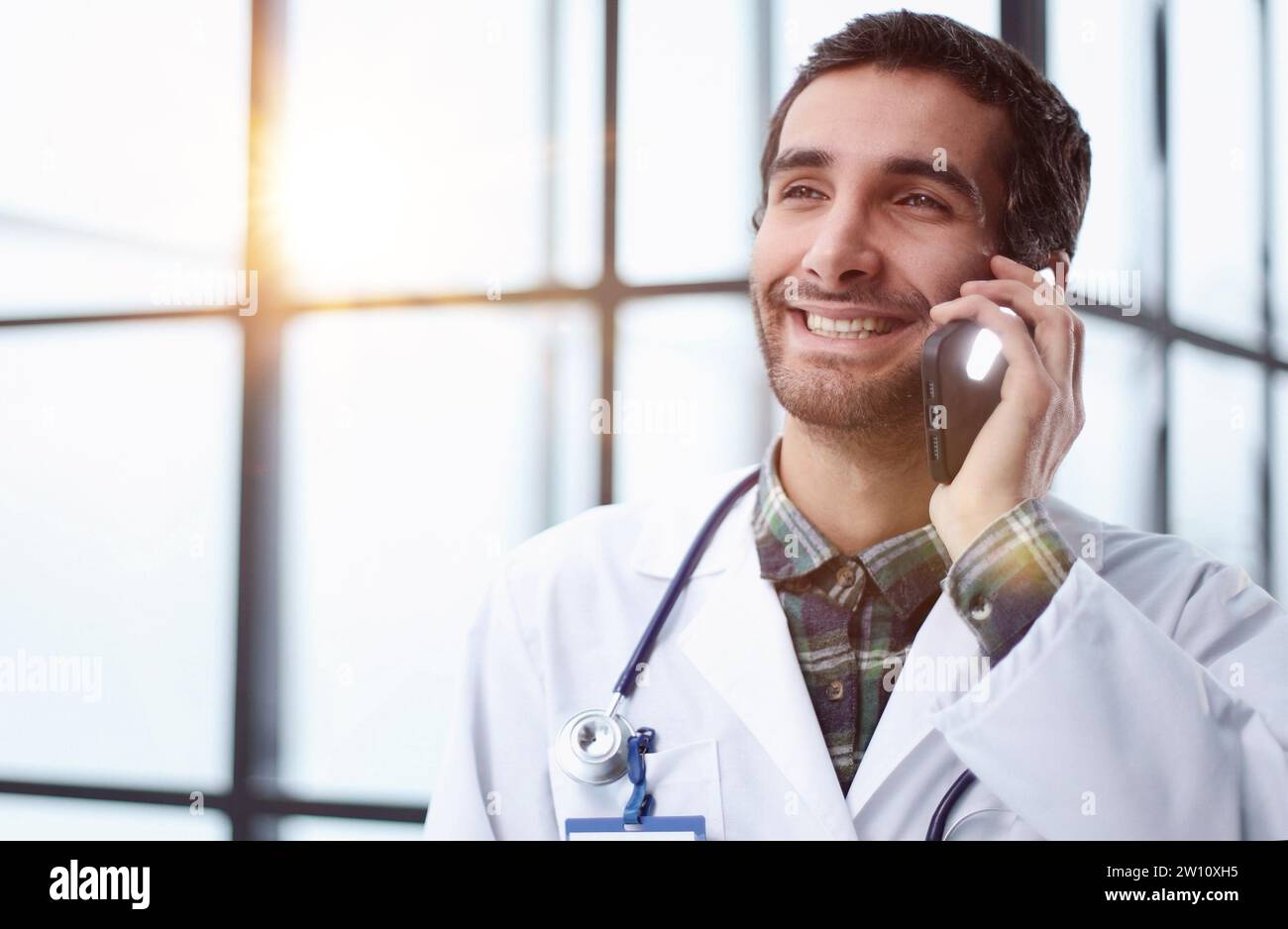 Phone call, male doctor doing a telehealth consultation in his office ...