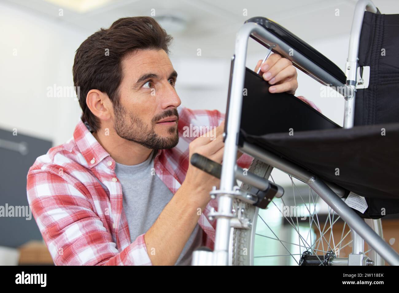 man repairing a wheelchair in his workshop Stock Photo - Alamy