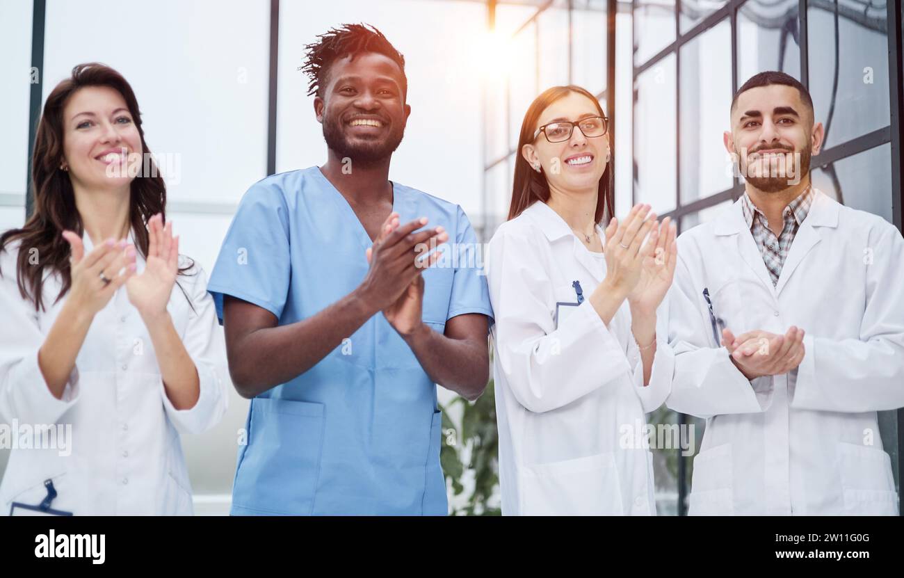Successful team of different doctors clapping hands Stock Photo - Alamy