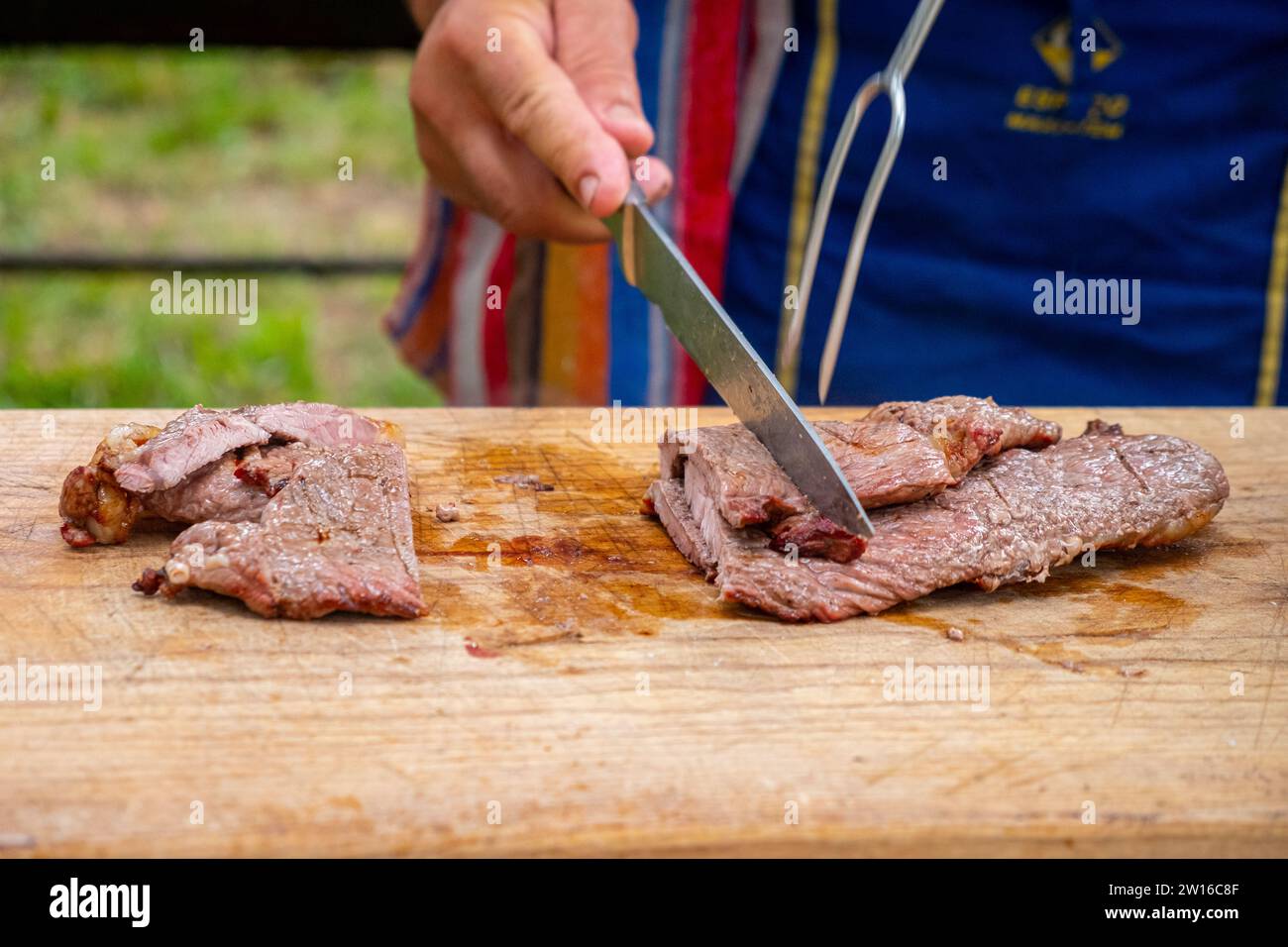 cook cutting grilled beef on the grill Stock Photo - Alamy